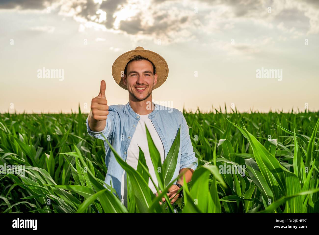 Glücklicher Bauer, der den Daumen hochzeigt, während er in seinem ...