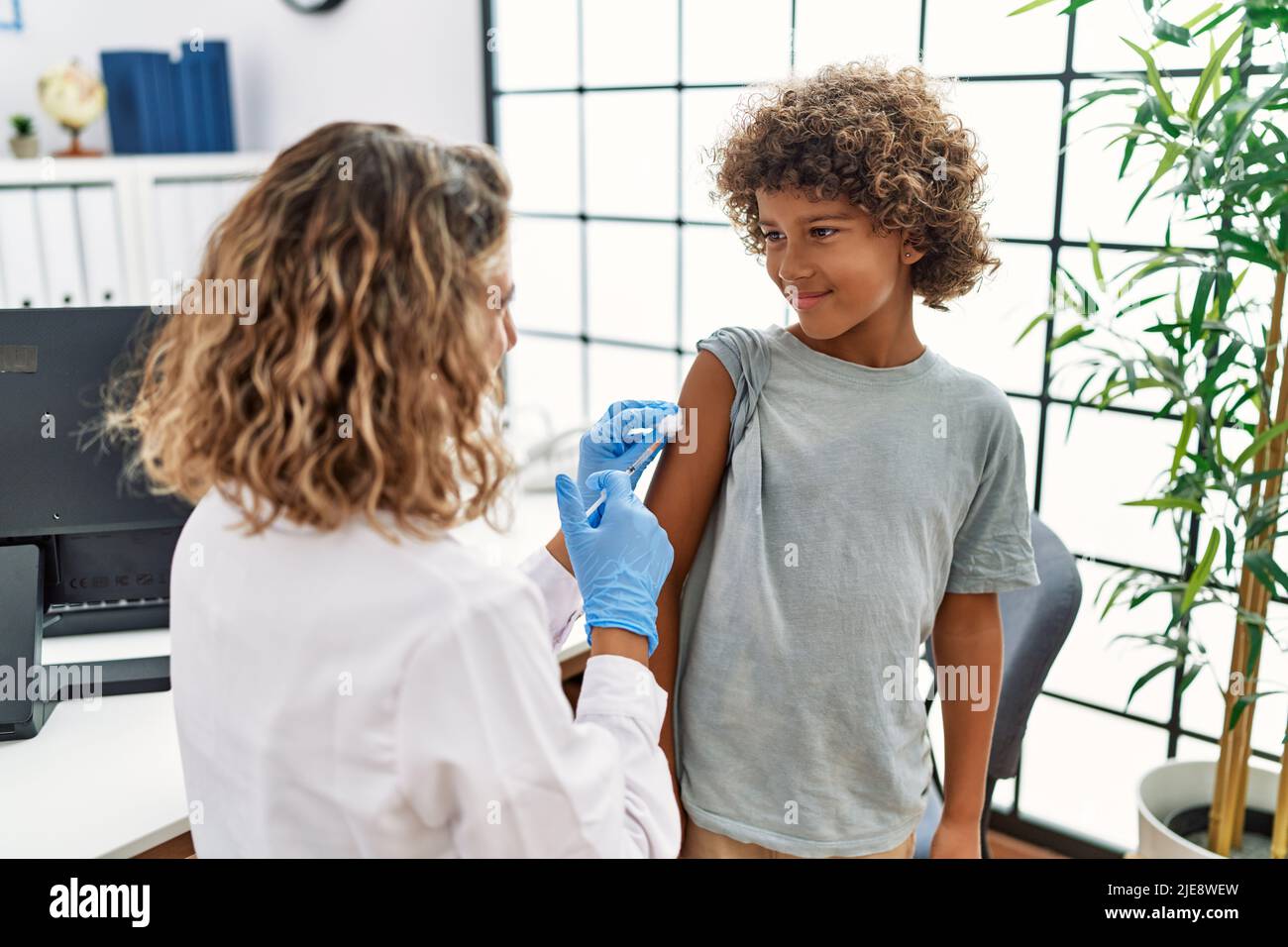 Mutter und Sohn tragen eine Arztzuniform, die das Kind in der Klinik ...