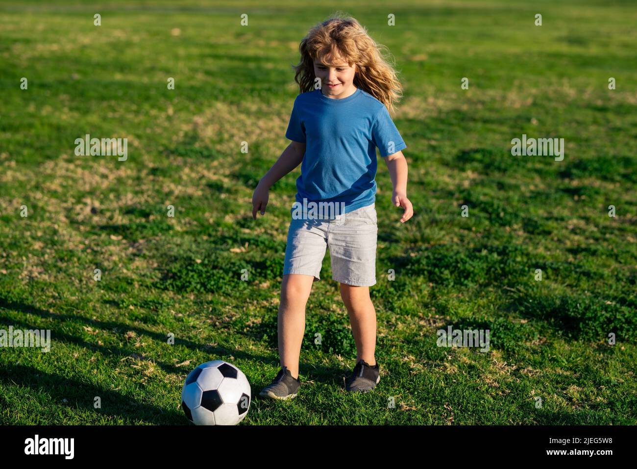 Junge Kind spielt Fußball auf dem Fußballplatz. Kinder spielen Fußball ...