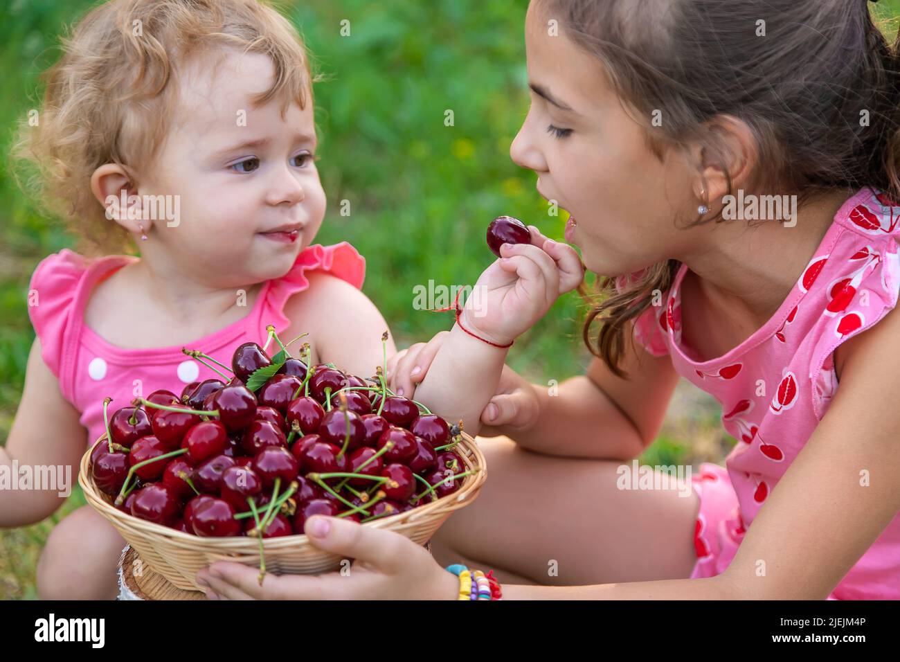 Das Kind isst Kirschen im Garten. Selektiver Fokus Stockfotografie - Alamy