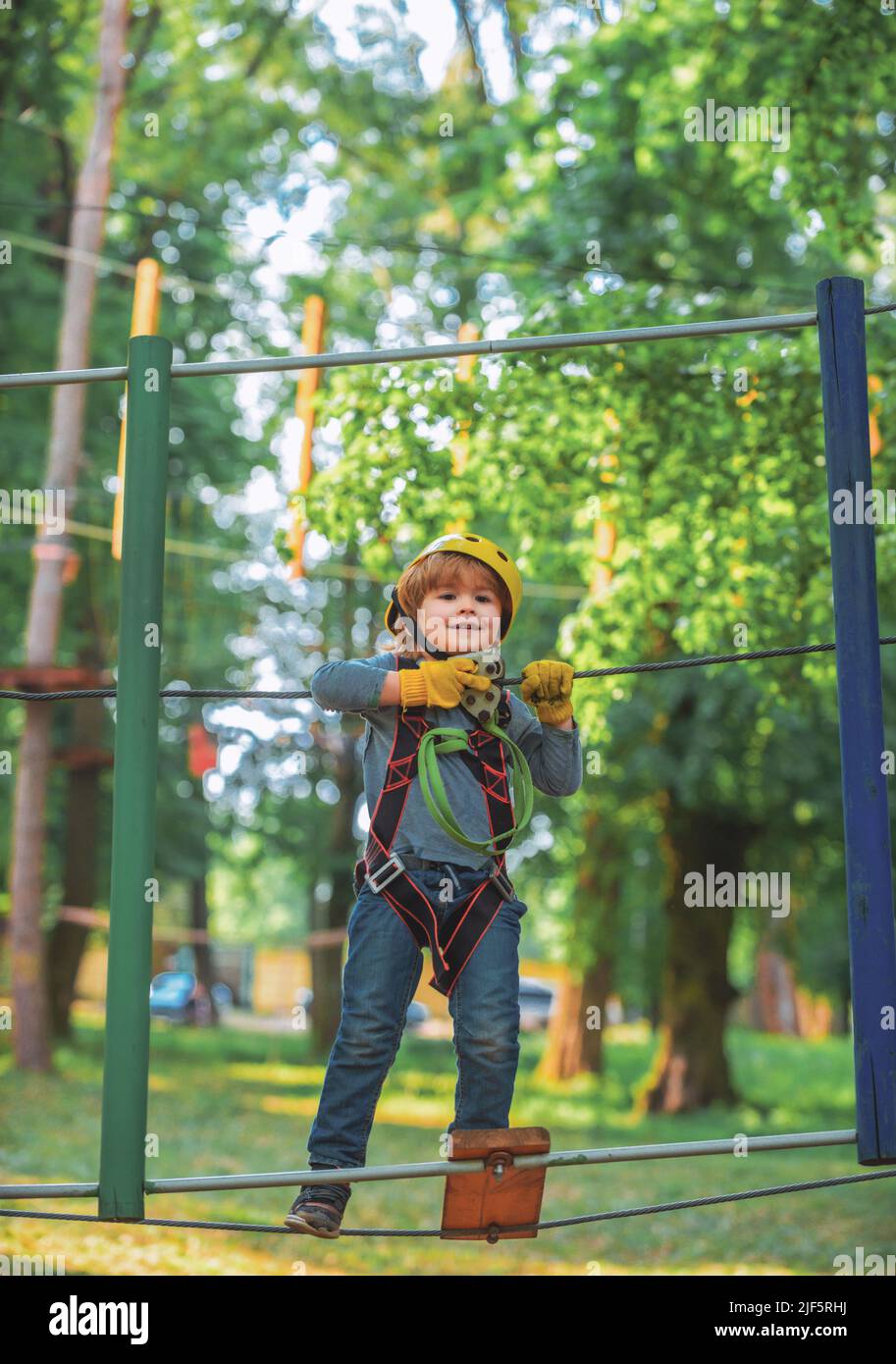 Kleiner Junge, der Spaß im Abenteuerpark hat. Glückliches Kind, das in ...