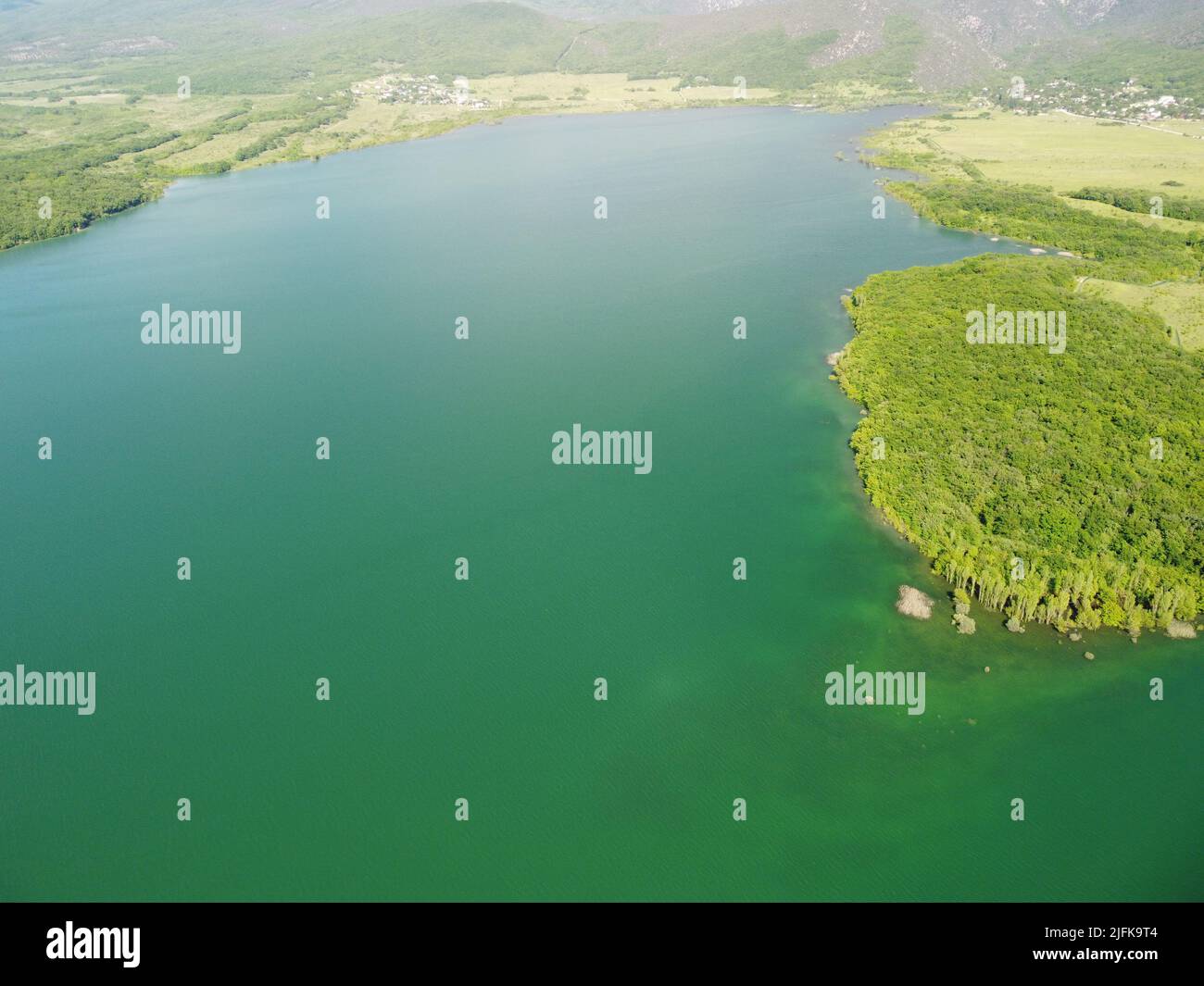 Luftaufnahme des Wasserreservoirs im Bergtal, das mit einem grünen ...