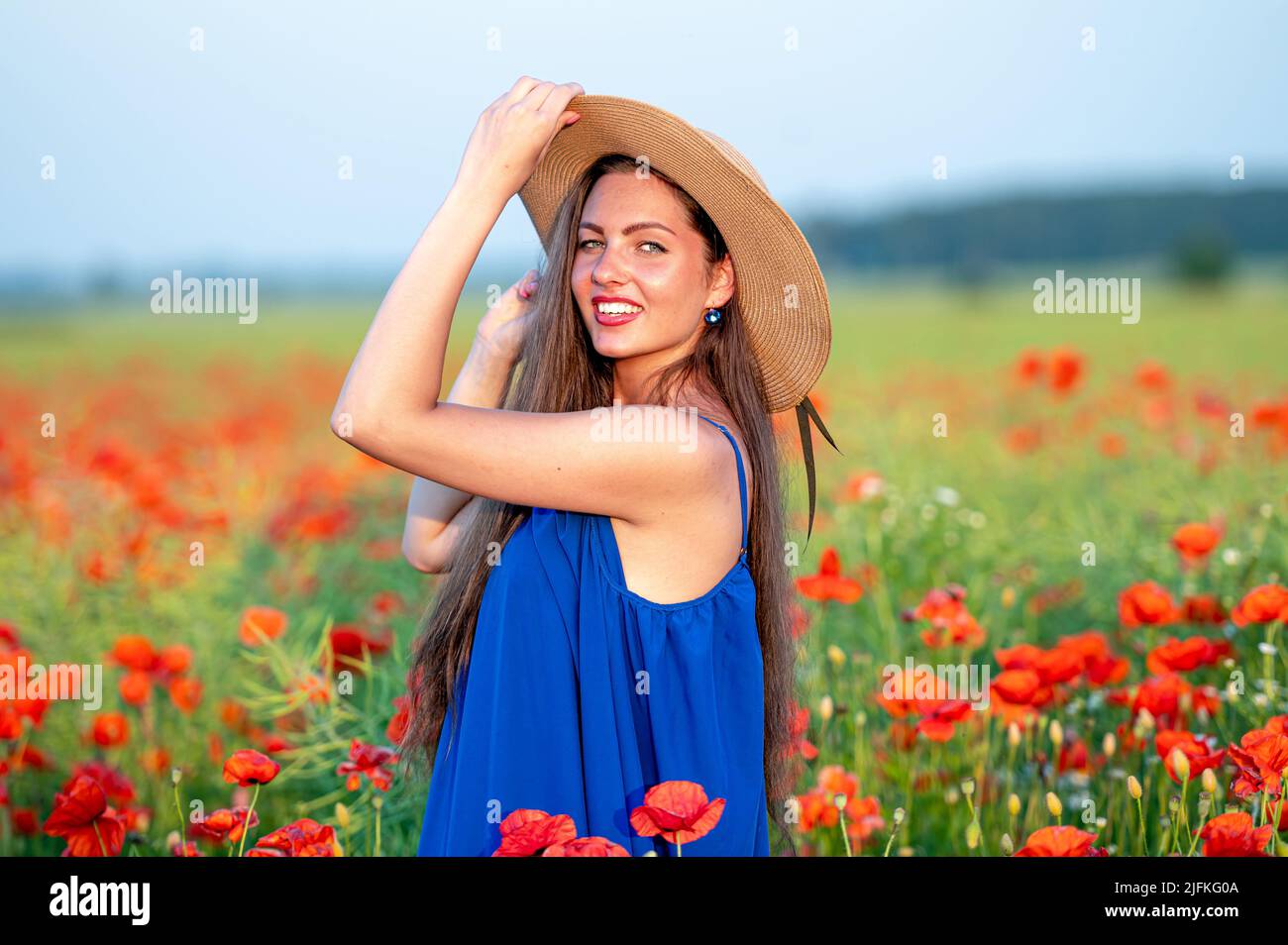 Porträt einer eleganten jungen Frau mit langen Haaren und Strohhut im ...