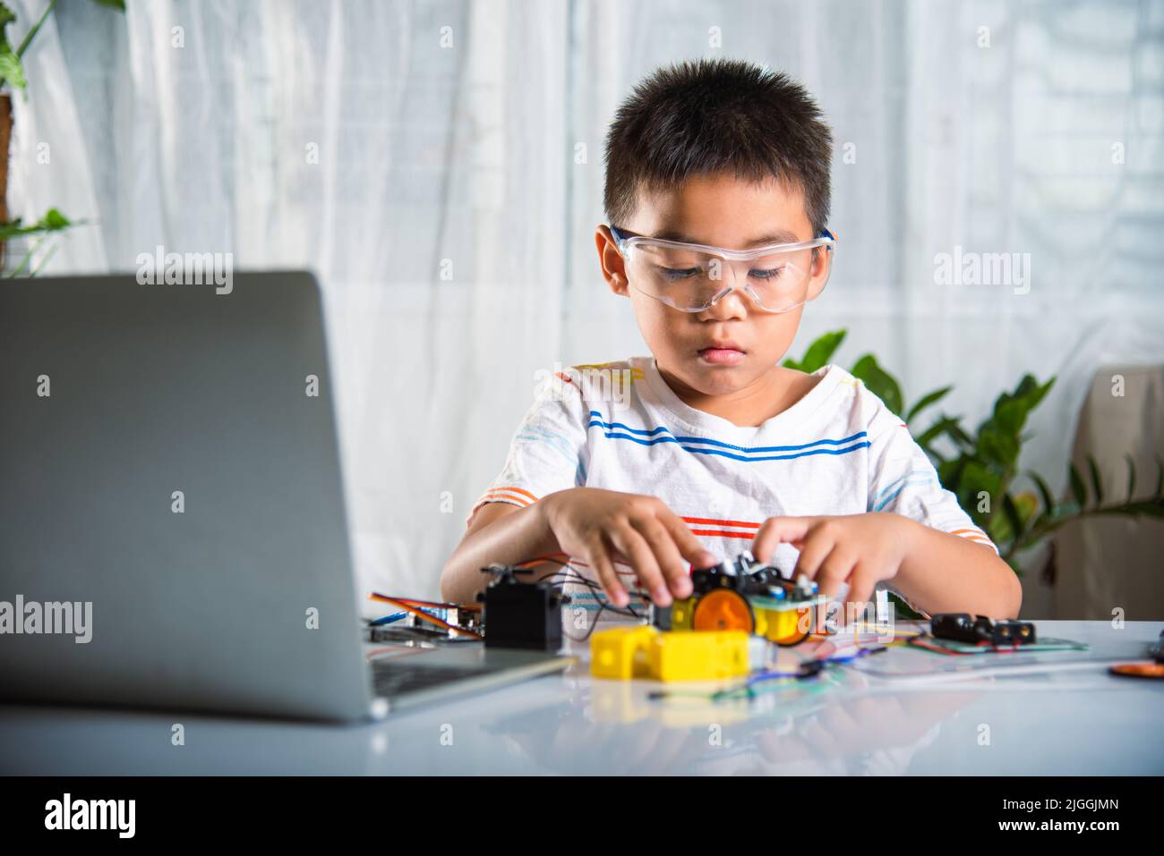 Asiatische Kind Junge Montage Rad in Arduino Roboter Auto Hausaufgaben ...