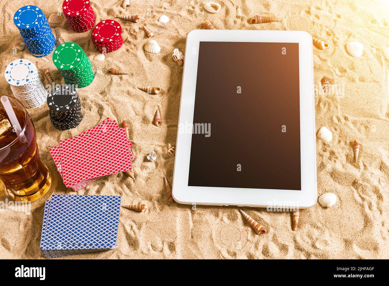 Online poker spiel auf dem Strand mit digitalen Tablet und Stapel von ...