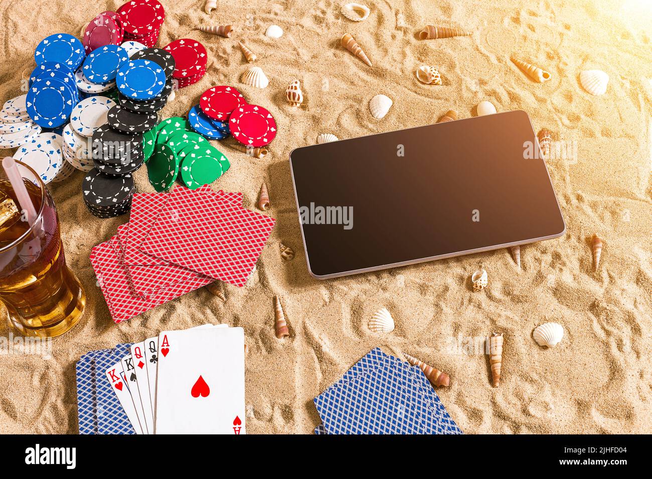 Online poker spiel auf dem Strand mit digitalen Tablet und Stapel von ...