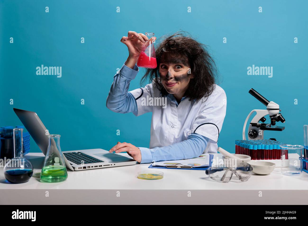Dumm lustig aussehende verrückte Chemiker mit Glaskolben gefüllt mit ...