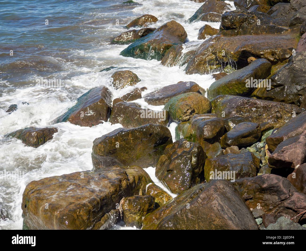 Surfen. Wellen stürzen auf große Felsen. Felsige Küste und Welle ...