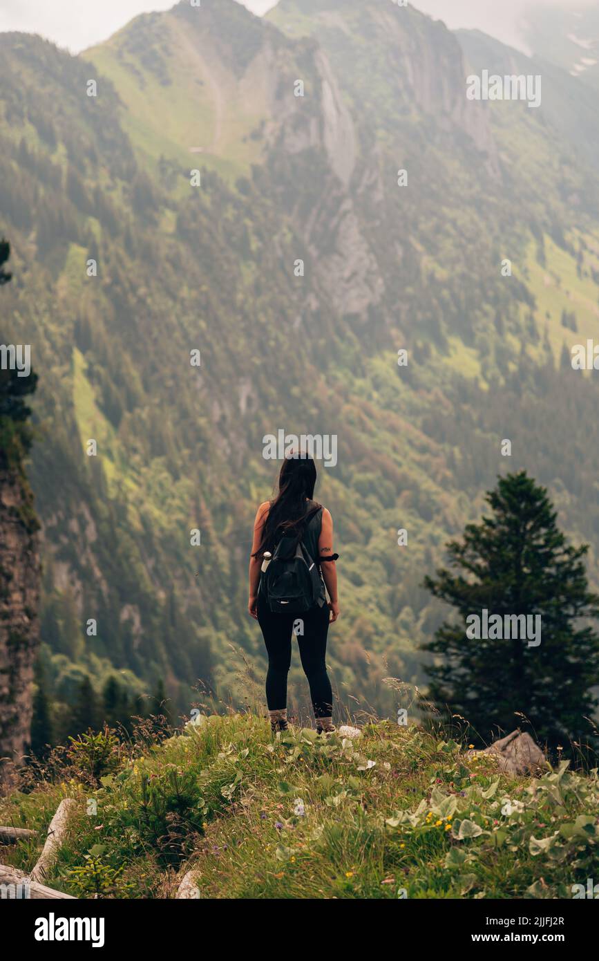 Eine vertikale Aufnahme einer Frau beim Wandern in den Appenzeller ...