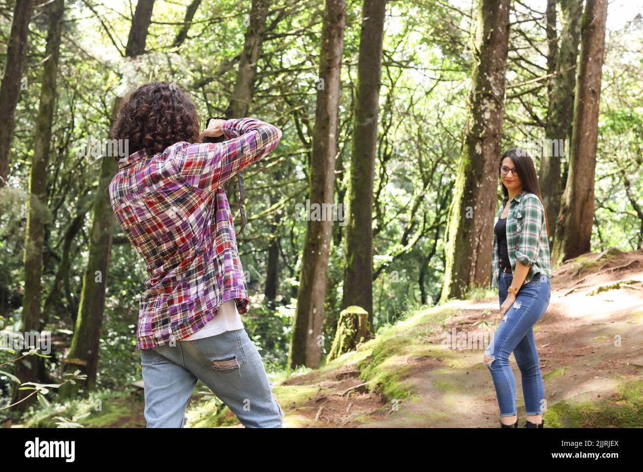 Anonymer professioneller Fotograf, der Fotos von Model-Posen im Wald ...