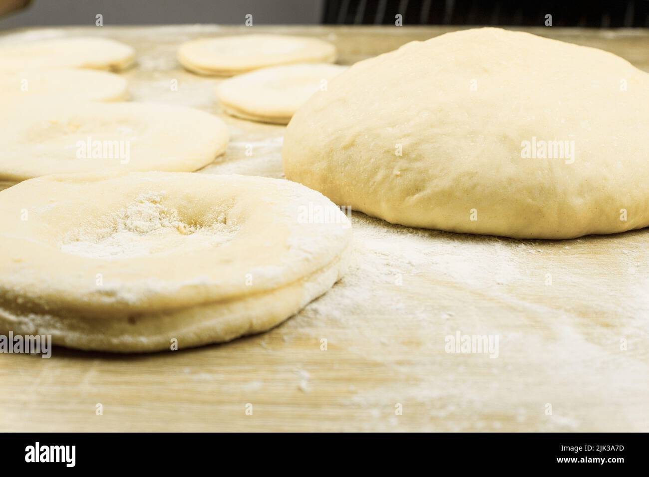 Der Teig rollte auf dem Tisch in Form von Kuchen aus. Der Teig zum ...