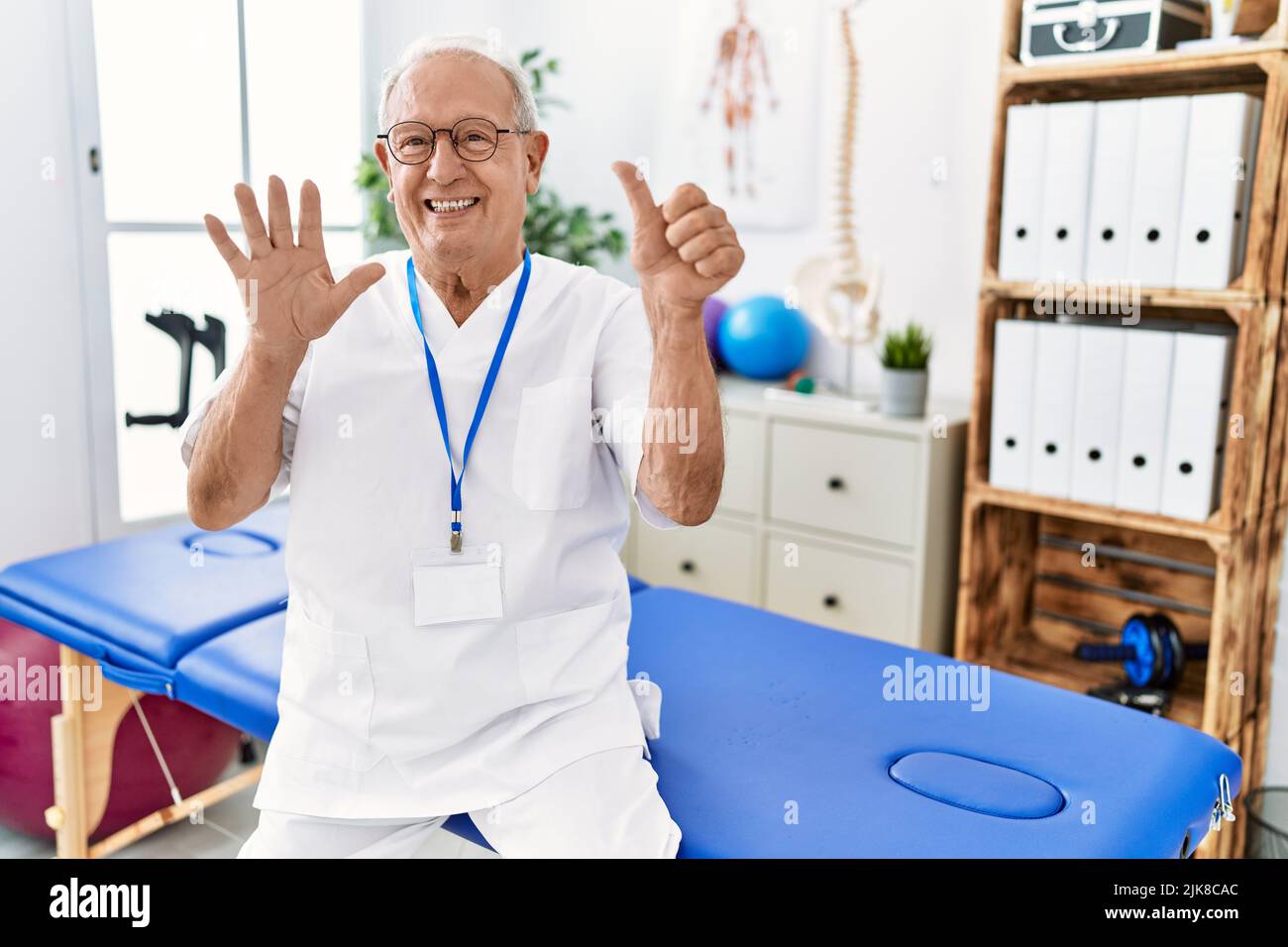 Leitender Physiotherapeut, der in der Schmerzklinik arbeitet, zeigt mit ...