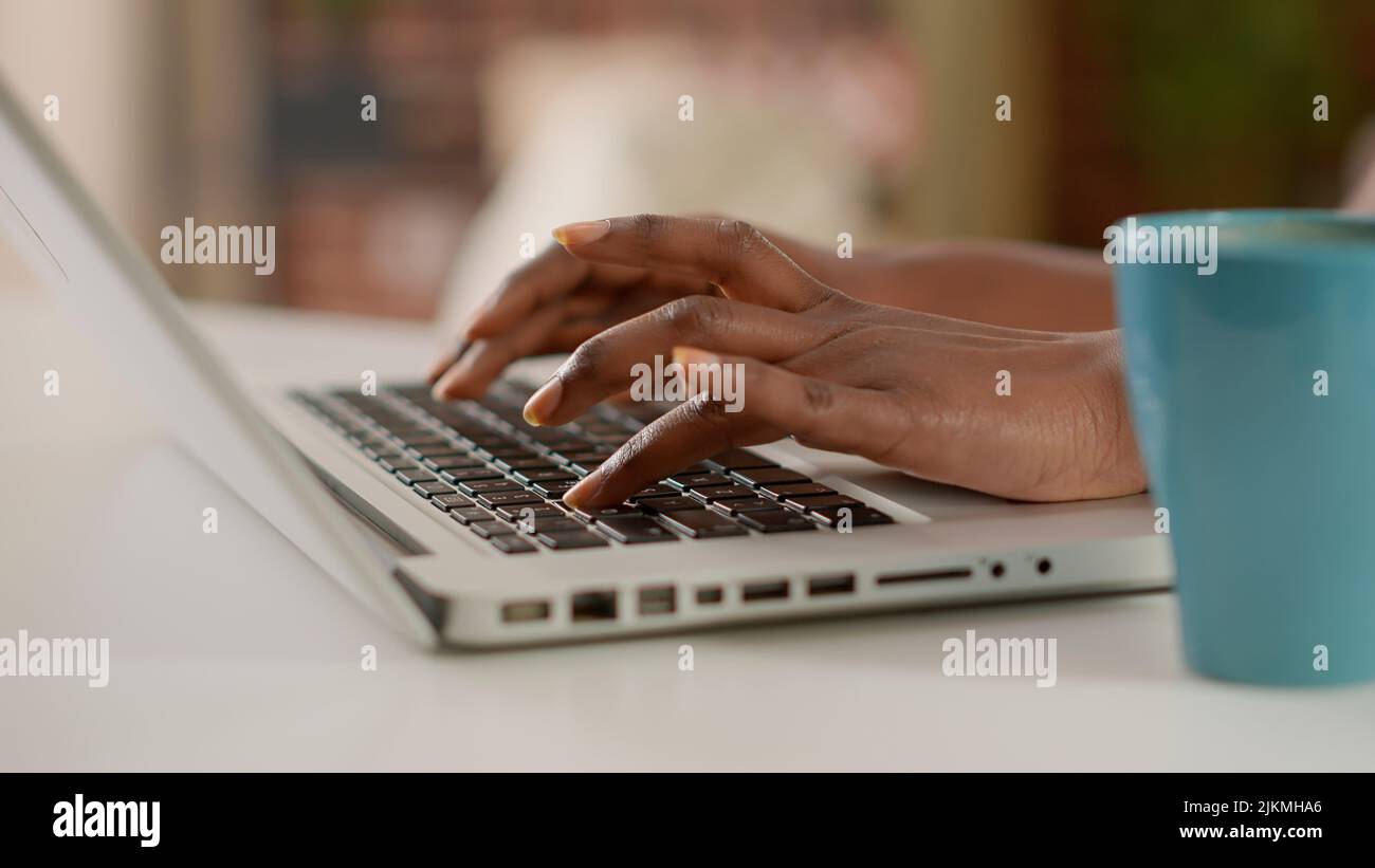 Junge Erwachsene geben Geschäftsinformationen auf dem Laptop ein ...