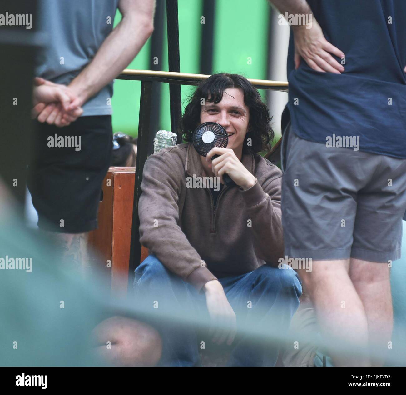 Tom Holland kühlt sich mit einem Fan ab, während er eine Pause von den ...