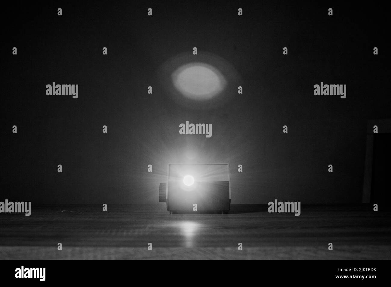 Ein Licht, das in einem schwarzen Raum reflektiert wird, mit glänzendem ...