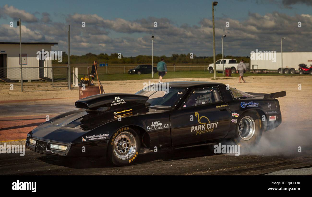 Das Auto wärmt die Reifen vor dem Drag-Rennen mit einer Rauchshow auf ...