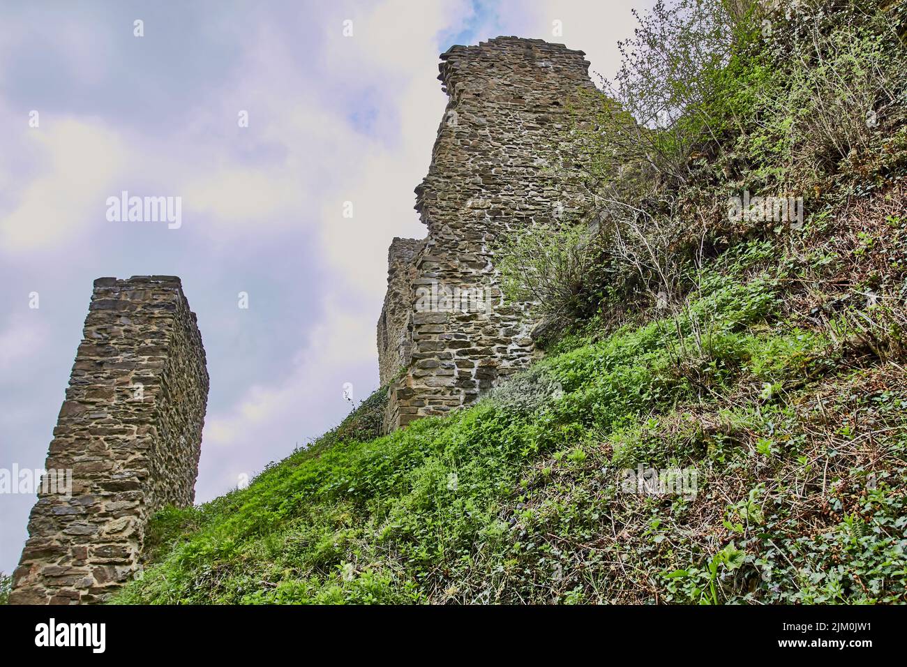 Eine Aufnahme der Ruinen der Lowenburger Burg auf einem grünen Hügel in ...