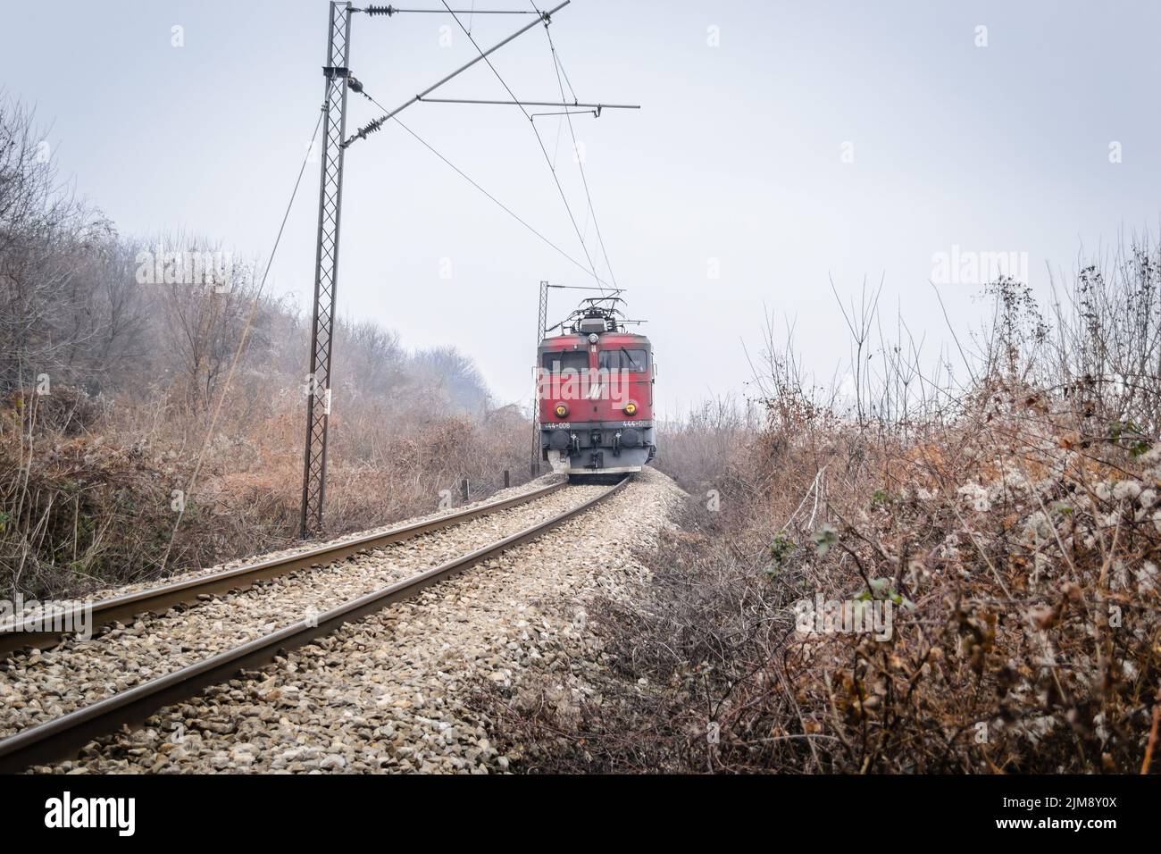 Blick auf die Bahnlinie im Winter. Eine alte elektrische Lokomotive auf ...