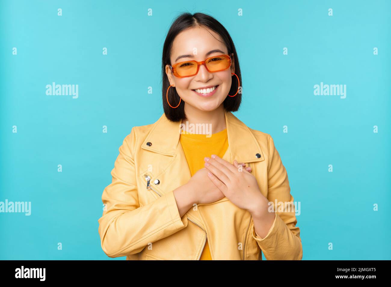 Porträt einer asiatischen Frau, die lächelt, die Hände am Herzen hält ...