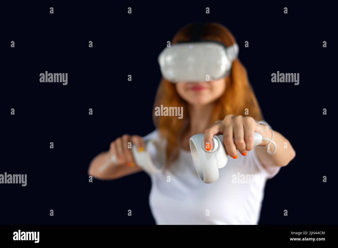 Ein junges Mädchen spielt in der virtuellen Realität. Weiße VR-Brille ...