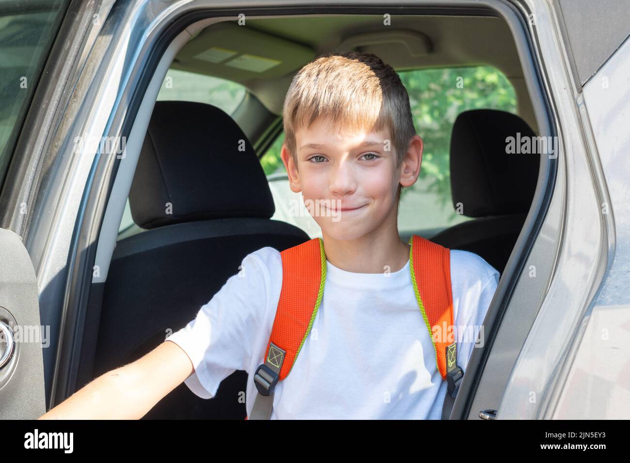 Porträt eines lächelnden Jungen mit einer Schultasche, die in einem ...
