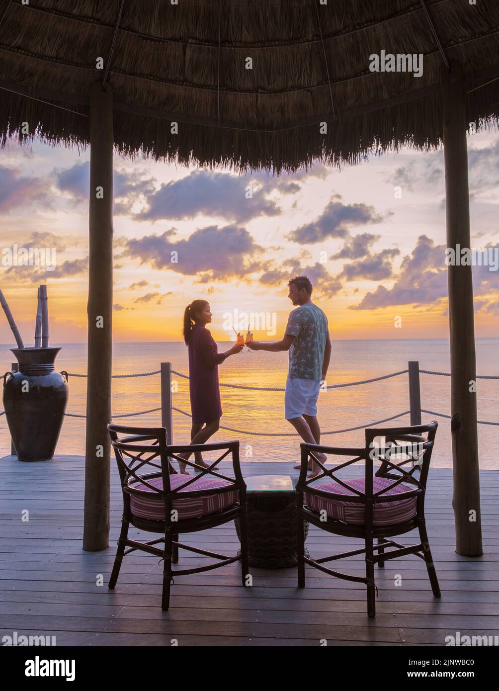 Paar trinken Cocktails am Strand mit Palmen und beobachten den ...