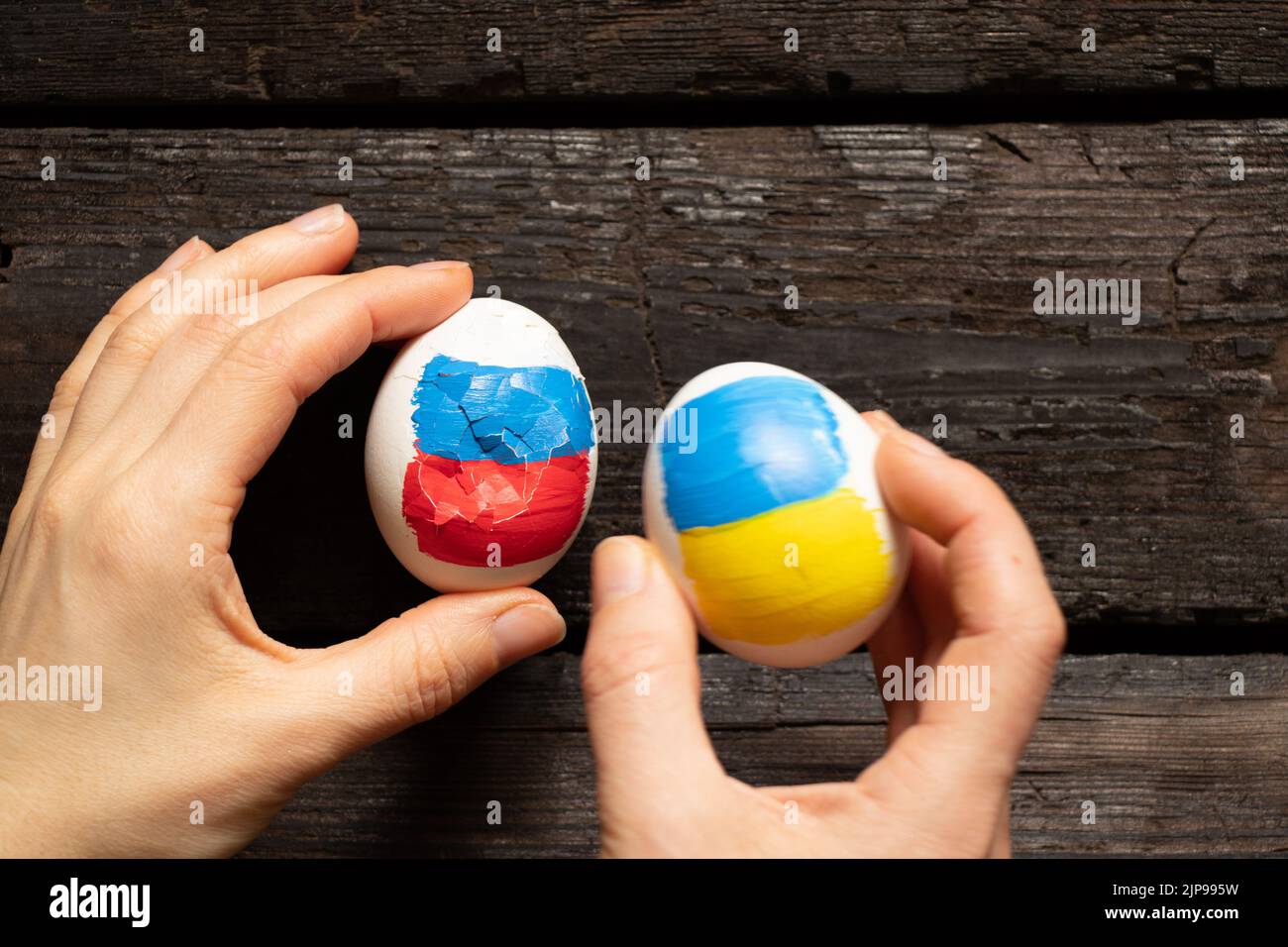 Zwei Hühnereier, eines mit der Flagge Russlands ist gebrochen und das ...