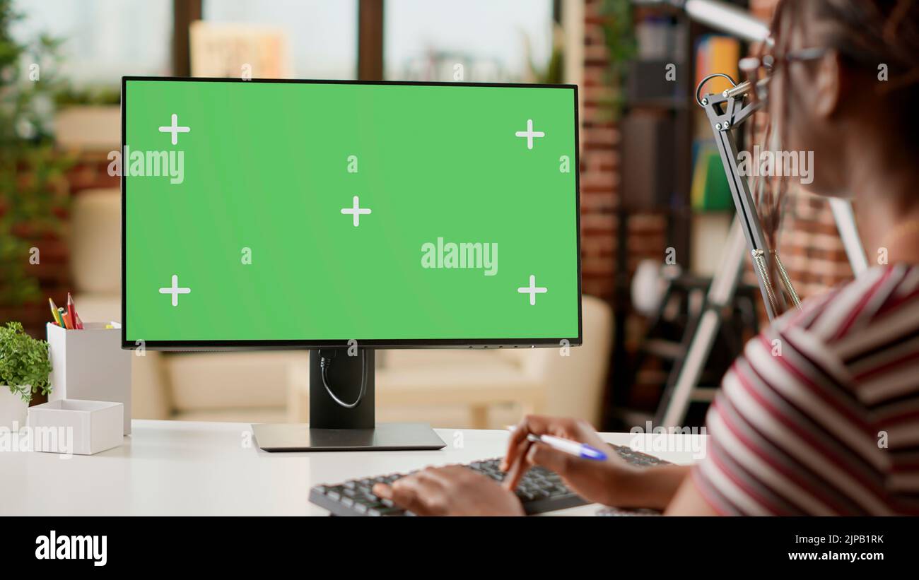 Geschäftsfrau, die per Fernzugriff mit Greenscreen auf dem Computer ...