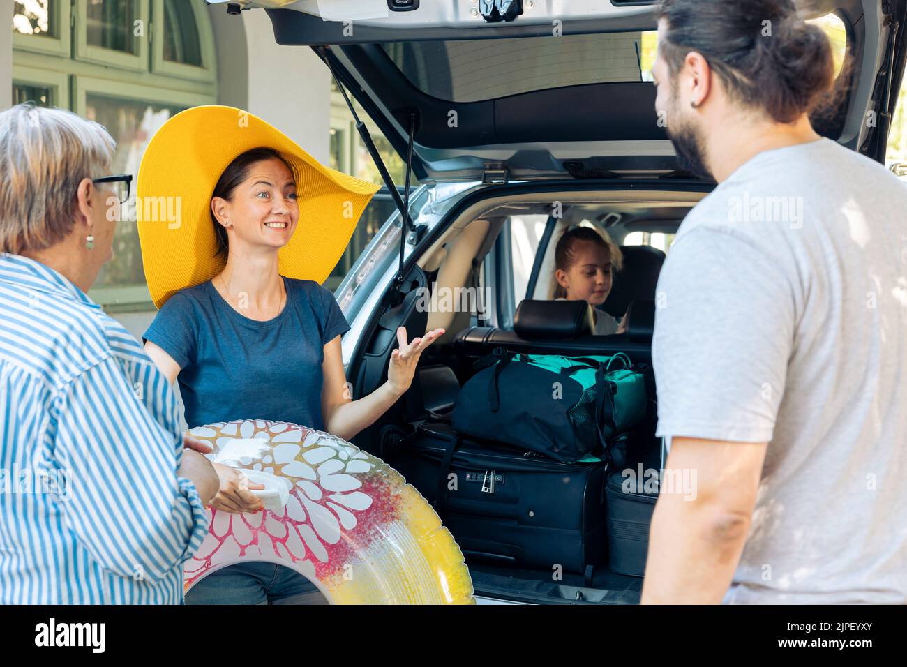 Glückliche Familie, die im Urlaub am Meer unterwegs ist und mit Koffer ...