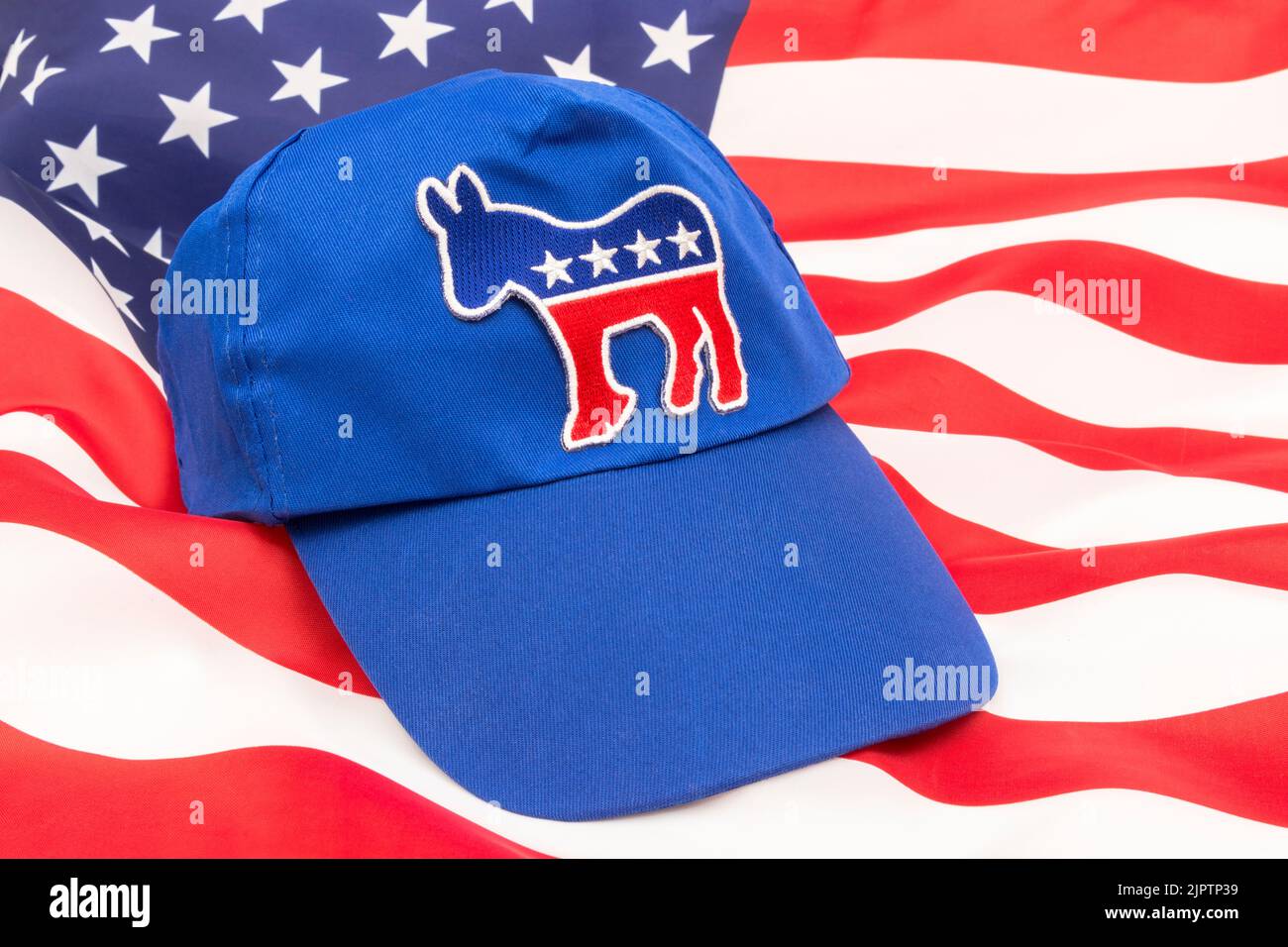 Blaue DNC-Kappe mit dem Esel-Emblem und US Stars and Stripes Flagge ...