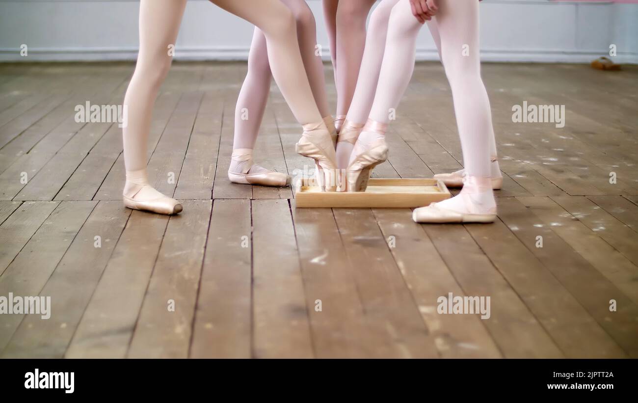 Nahaufnahme, die Füße junger Tänzer, die Mädchen senken die Spitzen der ...