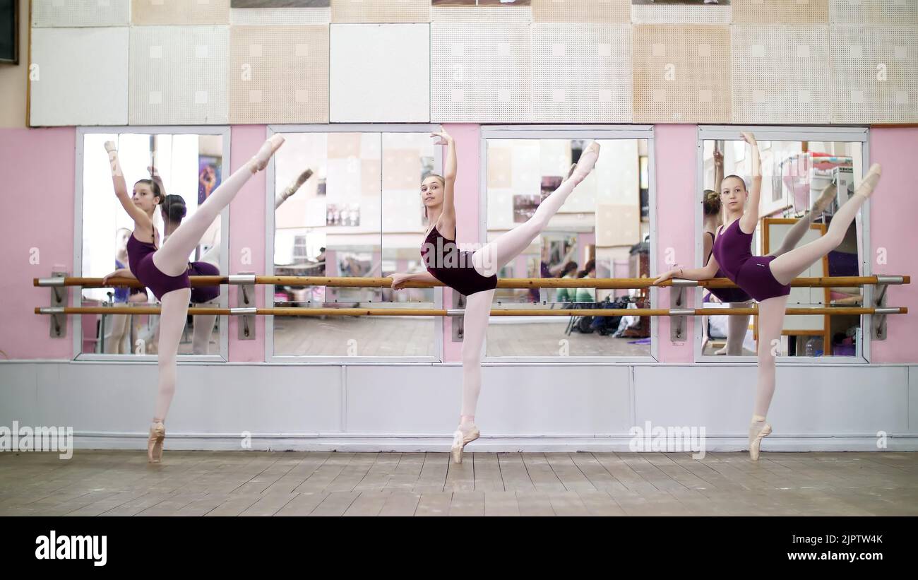 In der Tanzhalle führen junge Ballerinas in violetten Trikots auf ...