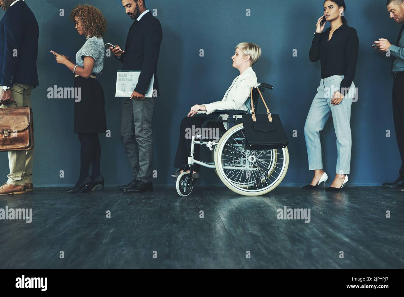 Die Stelle steht allen Bewerbern offen. Eine Frau im Rollstuhl wartet ...