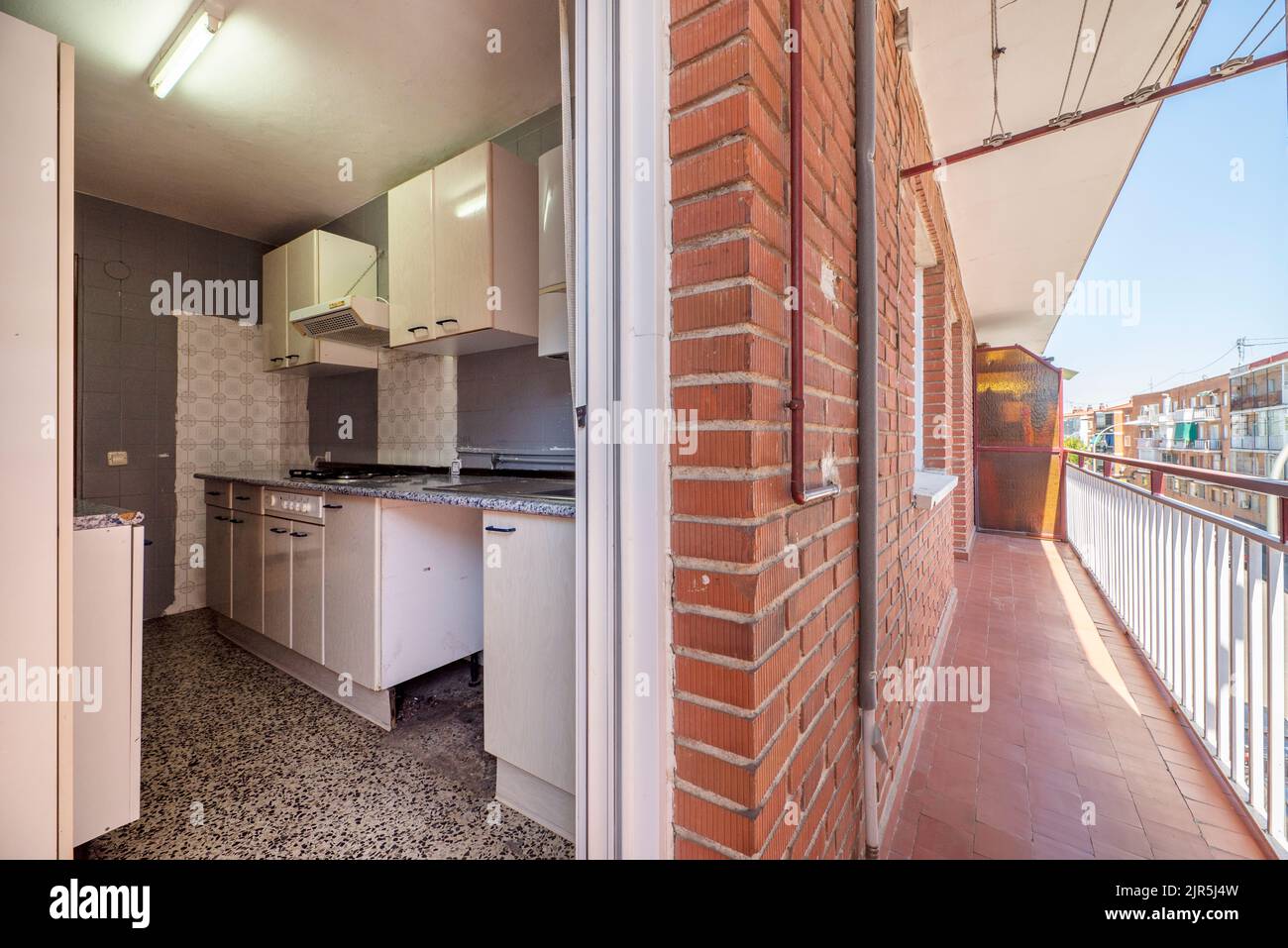 Lange Terrasse eines städtischen Wohnhauses mit weißem Metallgeländer ...