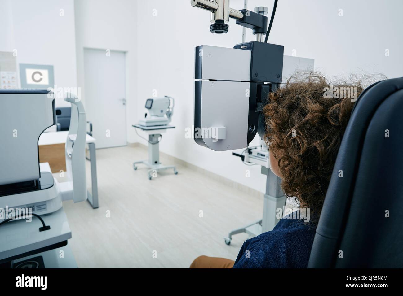 Männliches Kind hat einen Augentest in der Augenklinik mit Phoropter ...