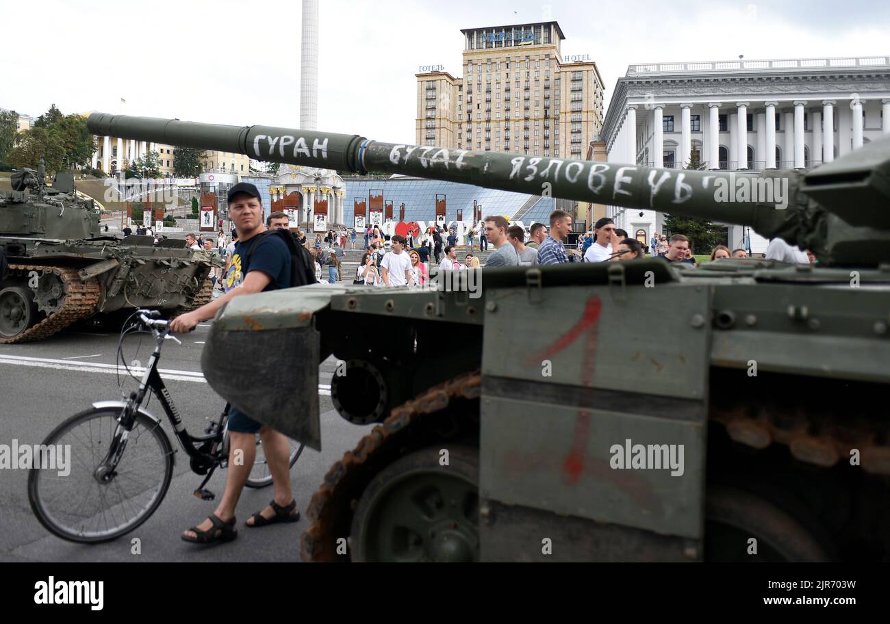 KIEW, UKRAINE - 20. AUGUST 2022 - Ein Mann mit einem Fahrrad betrachtet die zerstörte russische ...