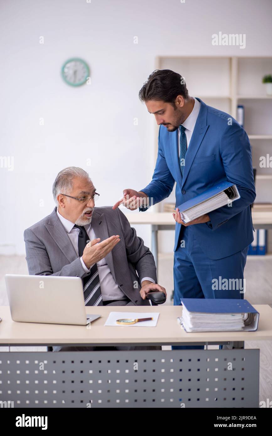 Alter Chef und junger Mitarbeiter am Arbeitsplatz Stockfotografie - Alamy