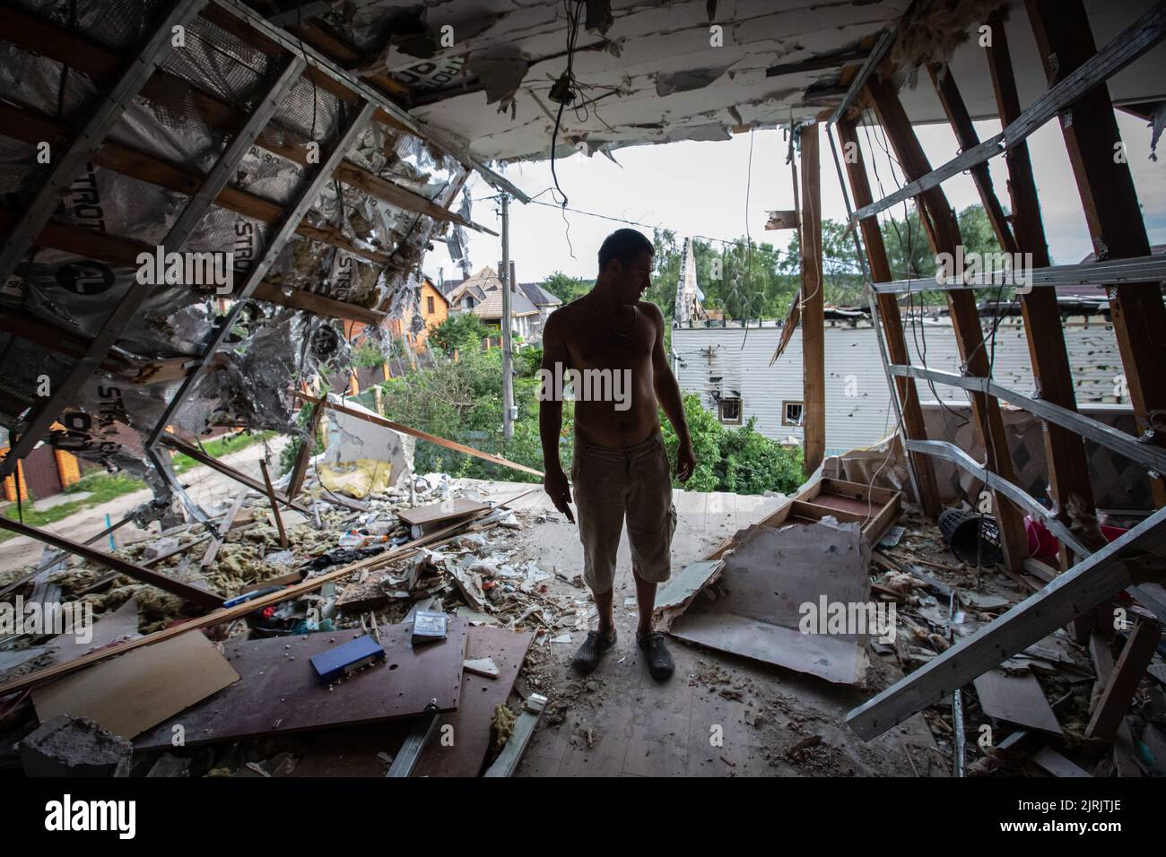 Ein Mann steht in seinem Haus, das infolge der russischen Invasion der ...