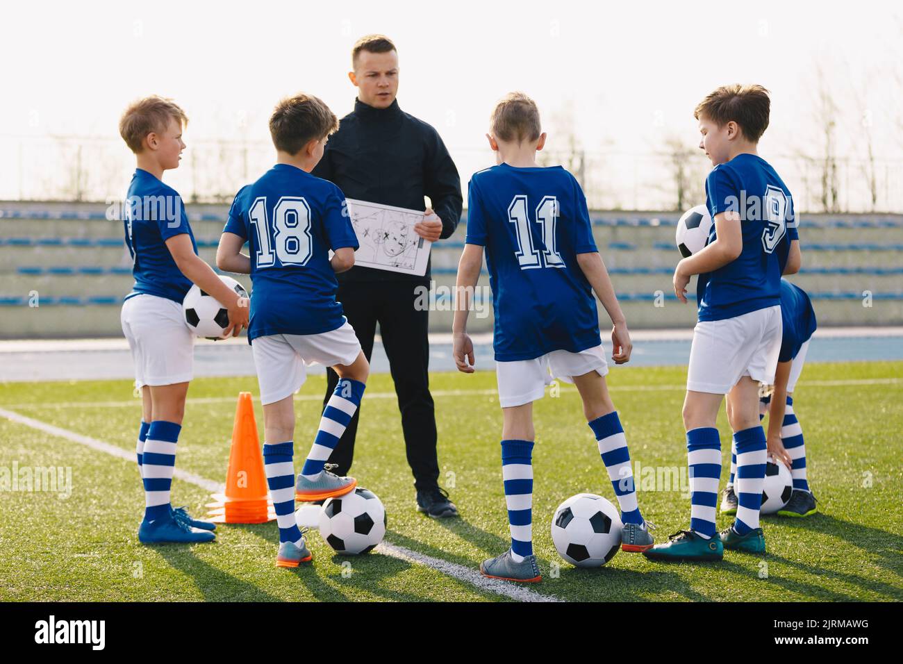 Fußballtrainer, der Kinder trainiert. Junger Trainer unterrichtet ...