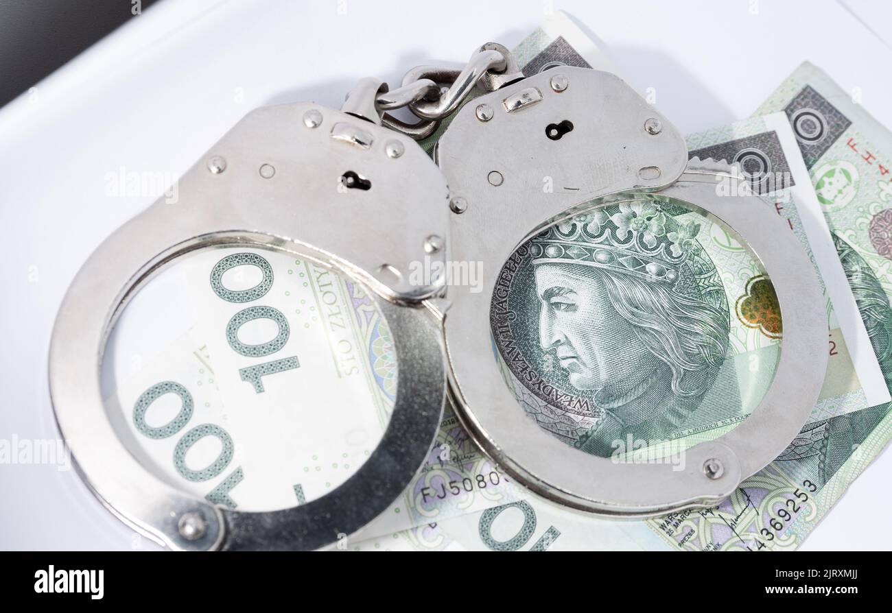 Handschellen und Banknoten der Polizei in polnischer Währung. Das ...