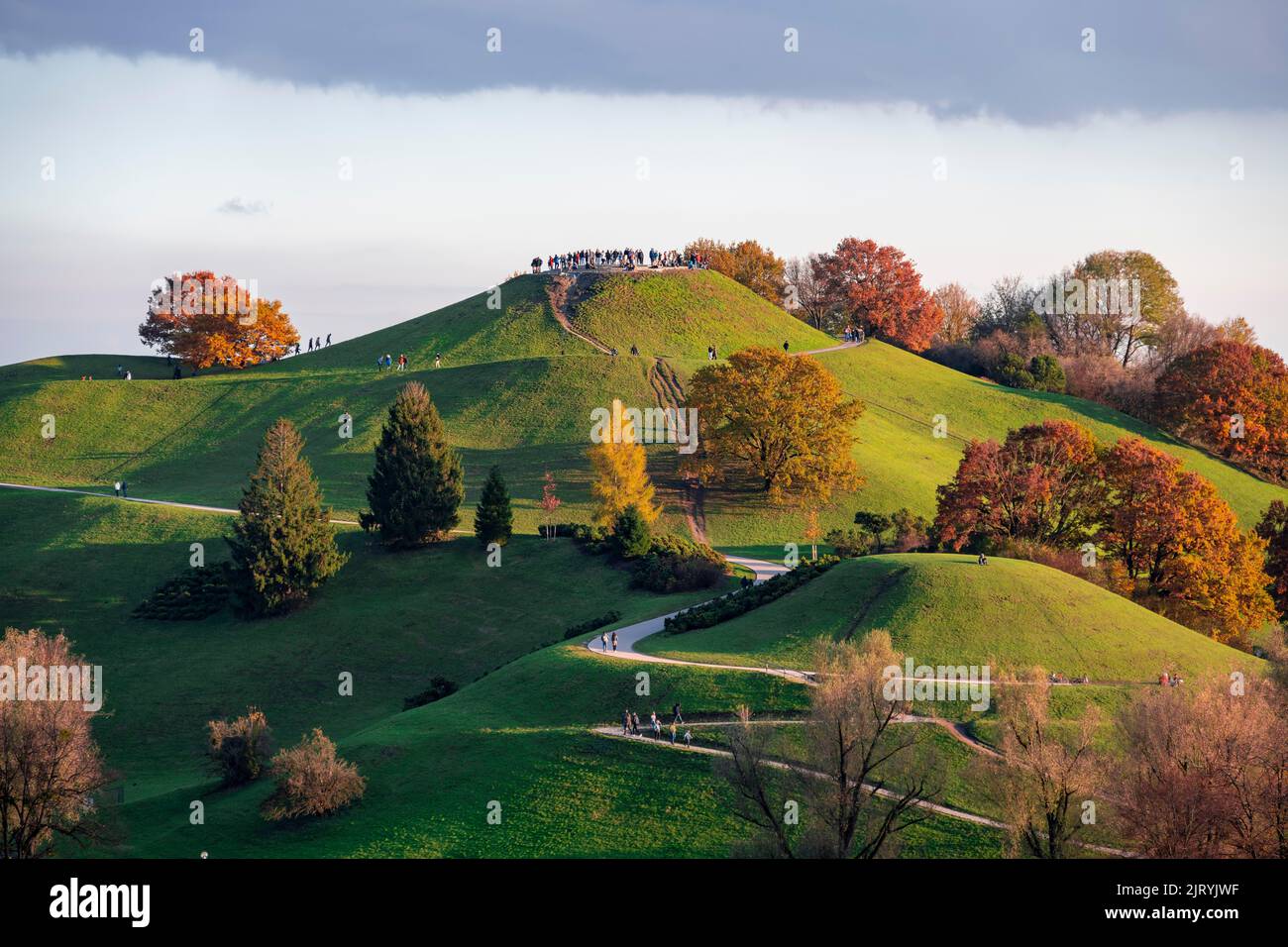 Herbstbäume im Olympiapark, Menschen am Aussichtspunkt Olympiaberg ...