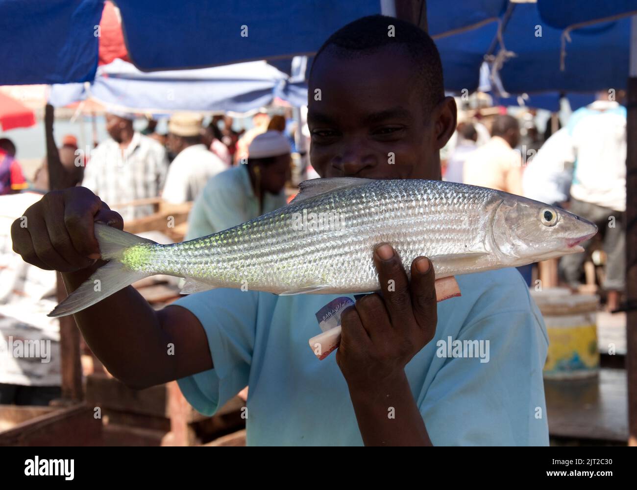 Der Fischhändler zeigt stolz einen großen Fisch, der auf dem Fish ...