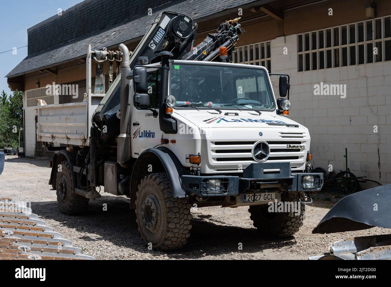 Ein weißer Mercedes Benz Unimog G5000 Geländewagen mit einem Kran, der ...