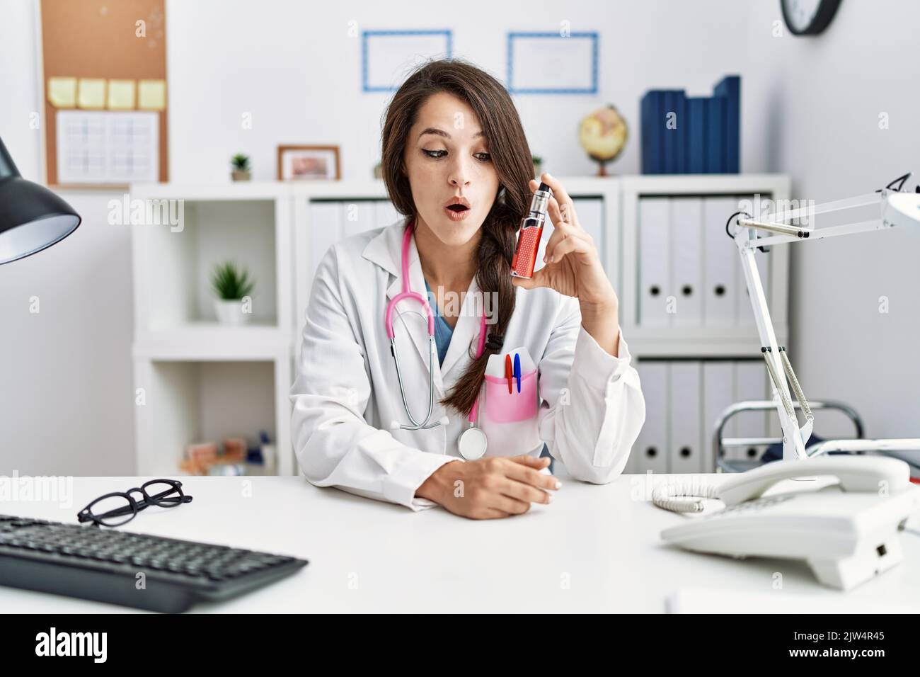 Junge Ärztin mit elektronischer Zigarette in der medizinischen Klinik ...
