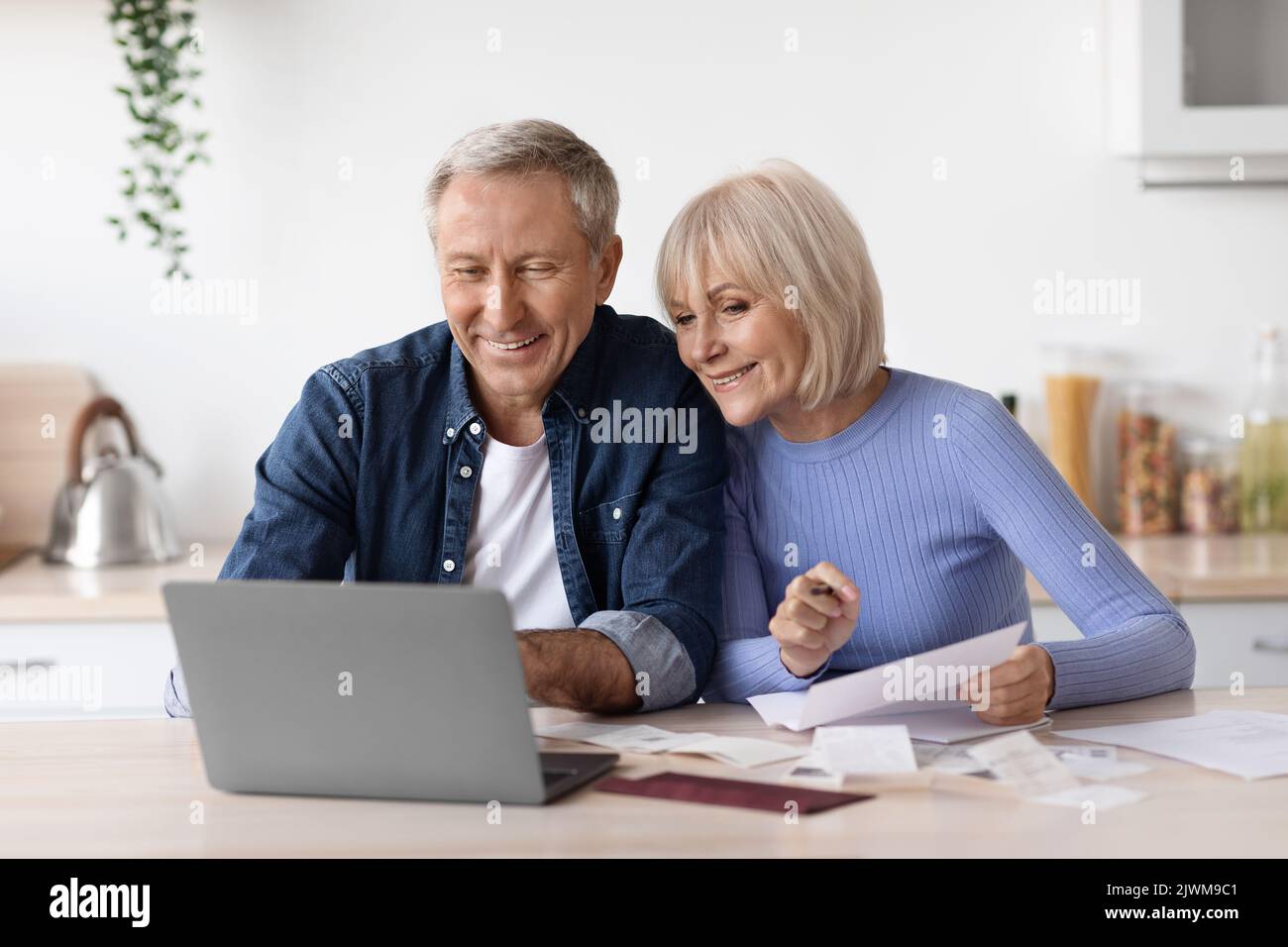 Glückliche Rentner, die vor dem Computer sitzen und E-Mails lesen ...