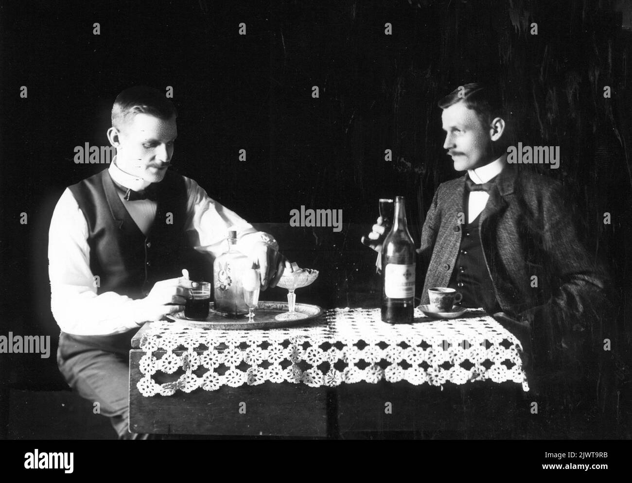 Zwei Männer, die trinken, schnappt sich an einem Tisch. Es kann ein ...