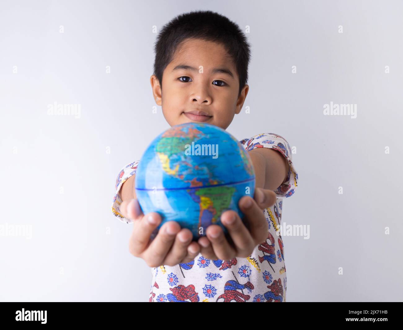 Boy hält einen Globus herausragen vor Zeigen Sie die Kraft der neuen ... Boy hält einen Globus herausragen vor Zeigen Sie die Kraft der neuen ...
