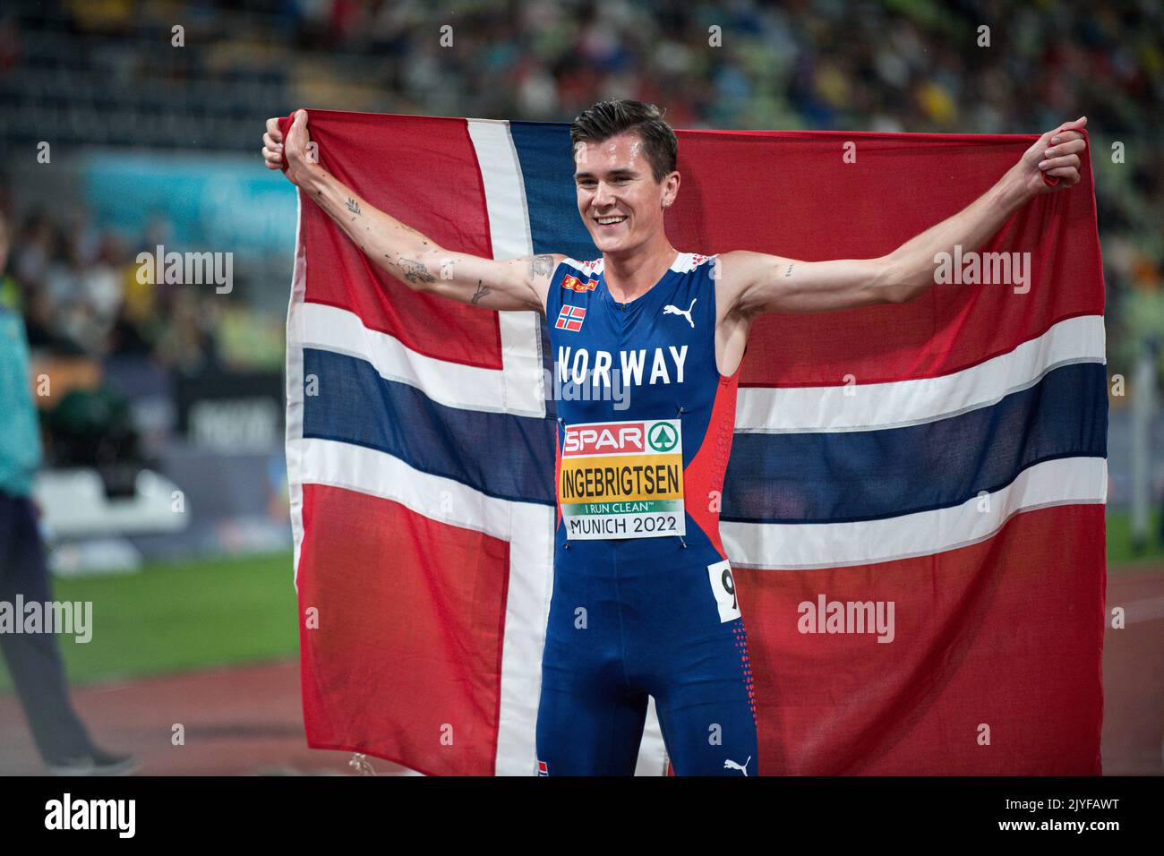 Jakob Ingebrigtsen mit der Landesflagge als Sieger der 1500 m bei den ...