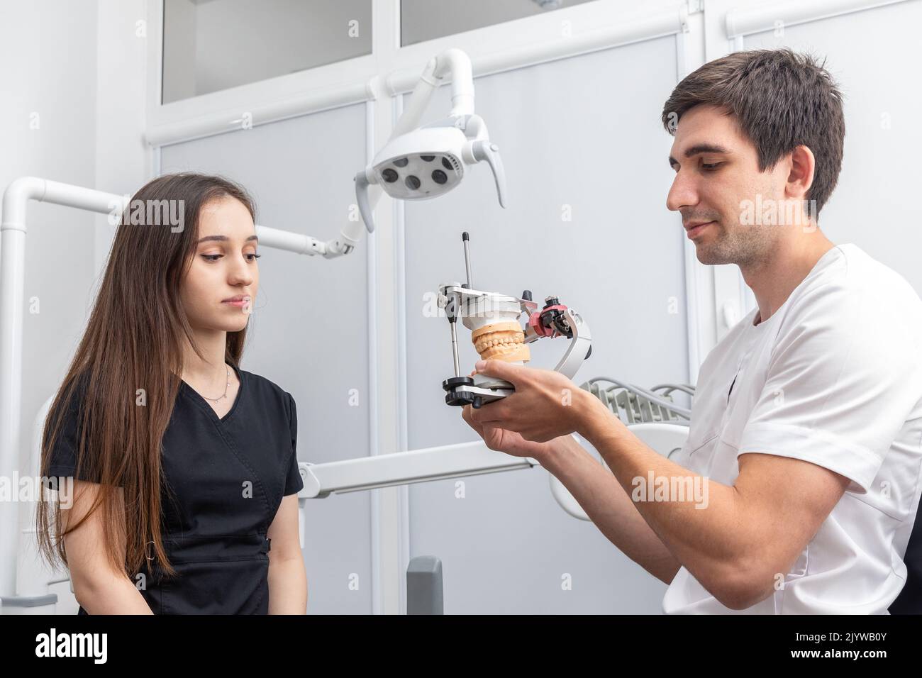 Zahnarzt mit Dental-Artikulator und Modell der Zahngipsprothese, das es ...