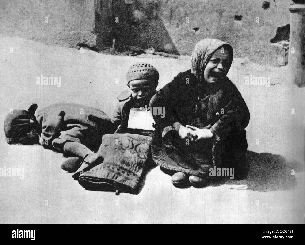 Hungernde jüdische Kinder sitzen verzweifelt auf einer Straße im ...